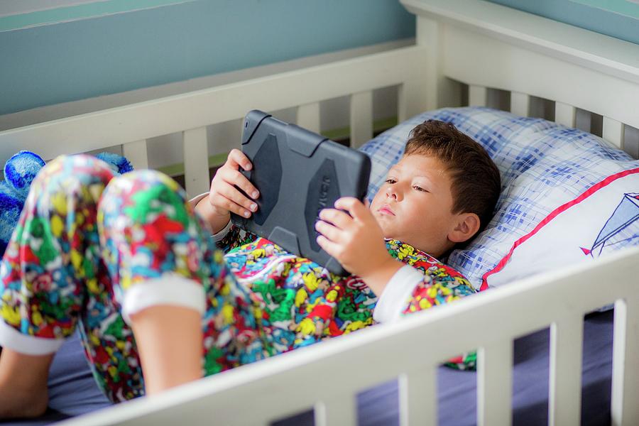 Boy In Bed Using A Digital Tablet Photograph by Samuel Ashfield - Fine ...