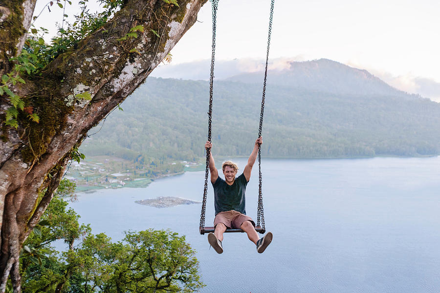 Man Sitting On Swing Against Lake Photograph by Konstantin Trubavin - Fine Art America