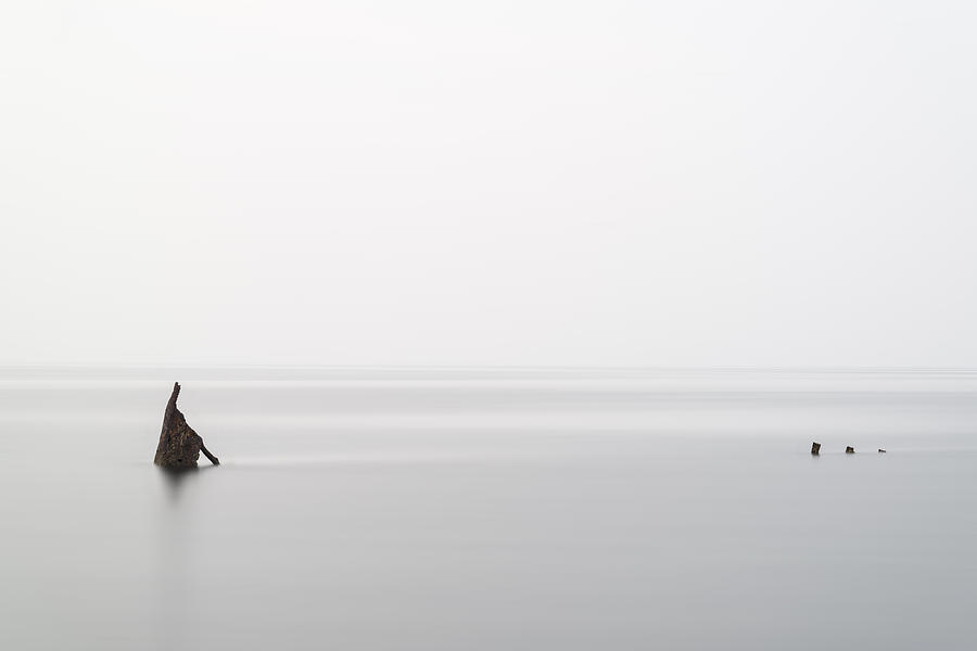 Minimal Landscape Image Of Shipwreck Poking Through Top Of Ocean