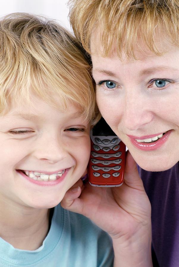 Mother And Son Listening To A Call by Science Photo Library