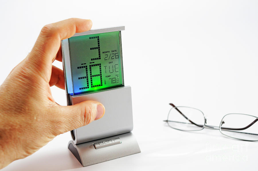 Man checking time on digital alarm clock Photograph by Sami Sarkis ...