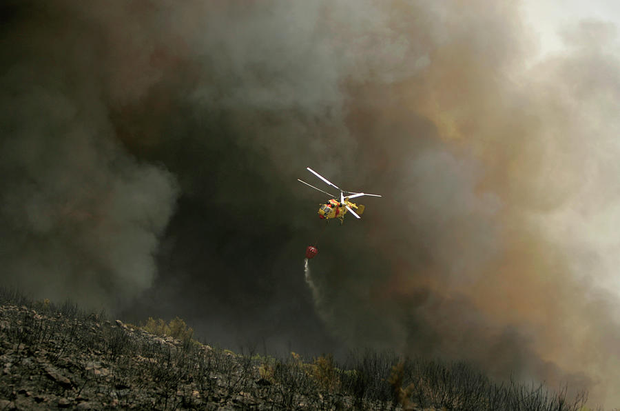 A Helicopter Drops Water over a Fire Photograph by Rafael Marchante ...