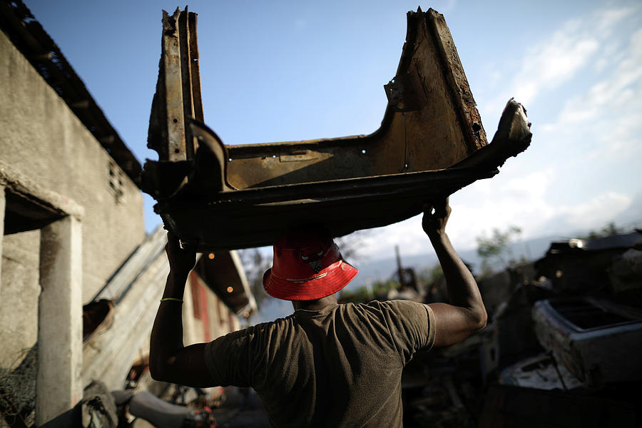 A Man Carries a Piece of Metal Photograph by Andres Martinez Casares ...