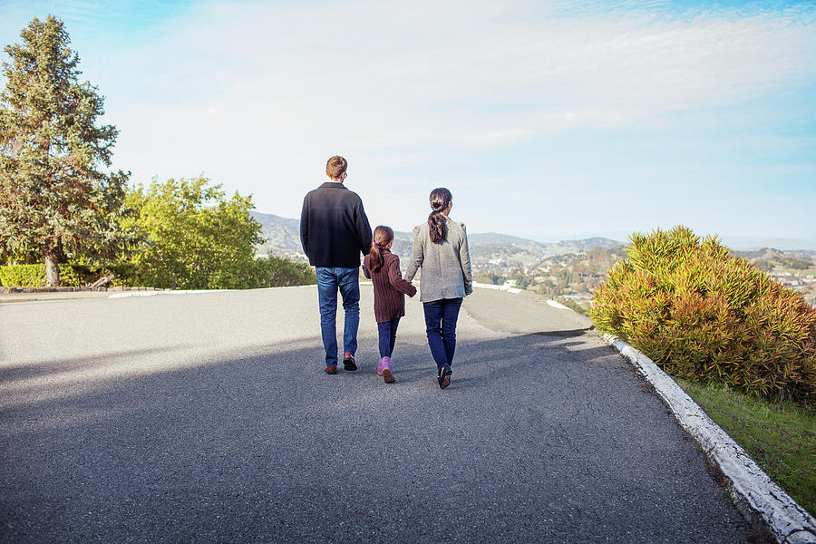 Rear View Of Family Walking On Footpath Against Clear Sky Photograph by ...