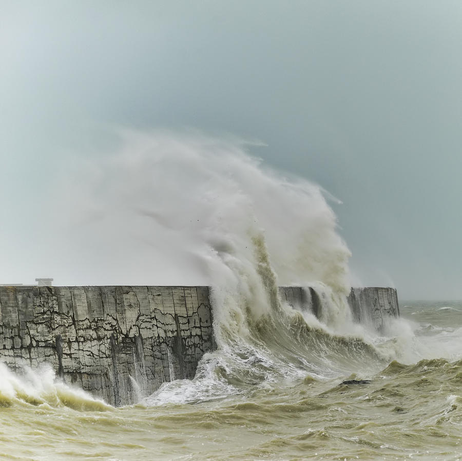 Stunning dangerous high waves crashing over harbor wall during w ...