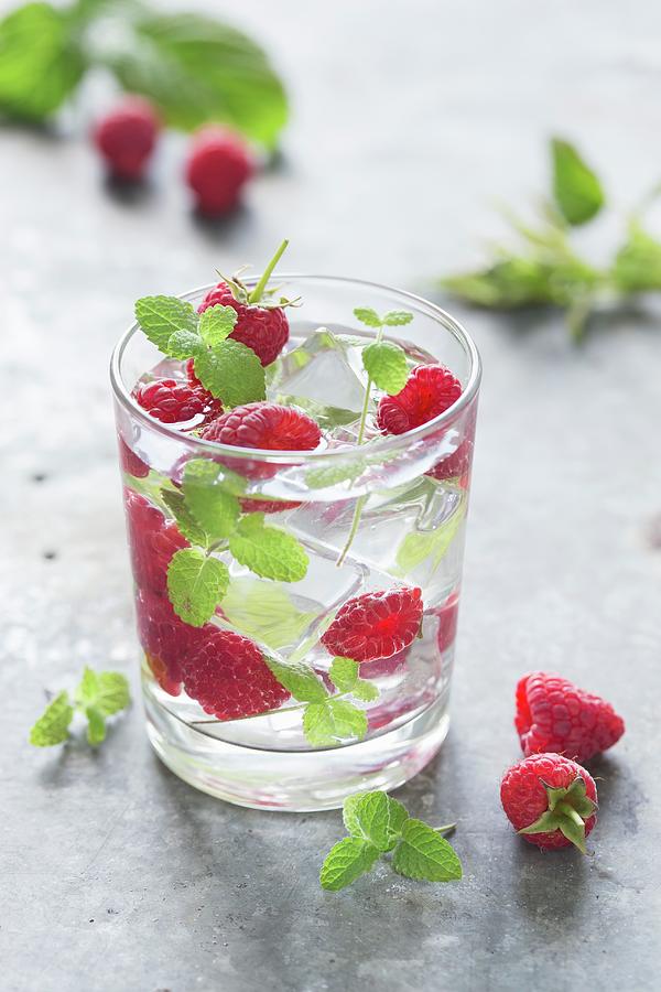 Water With Raspberries, Mint And Ice Cubes Photograph by Malgorzata ...