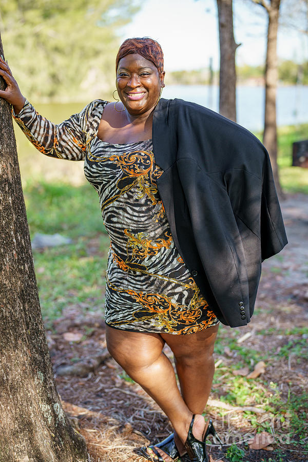 Beautiful black plus sized model posing by a tree in a tranquil park scene Photograph by Felix ...