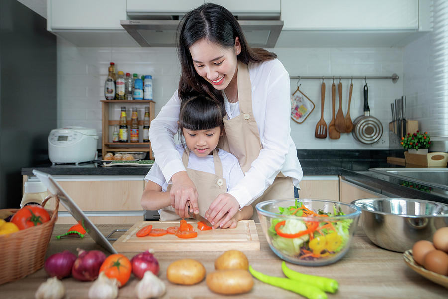 Asian mother and her daughter enjoy cooking togather Photograph by Anek Suwannaphoom - Pixels
