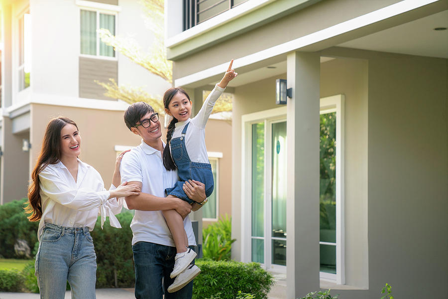 Beautiful family portrait smiling outside their new house with s ...