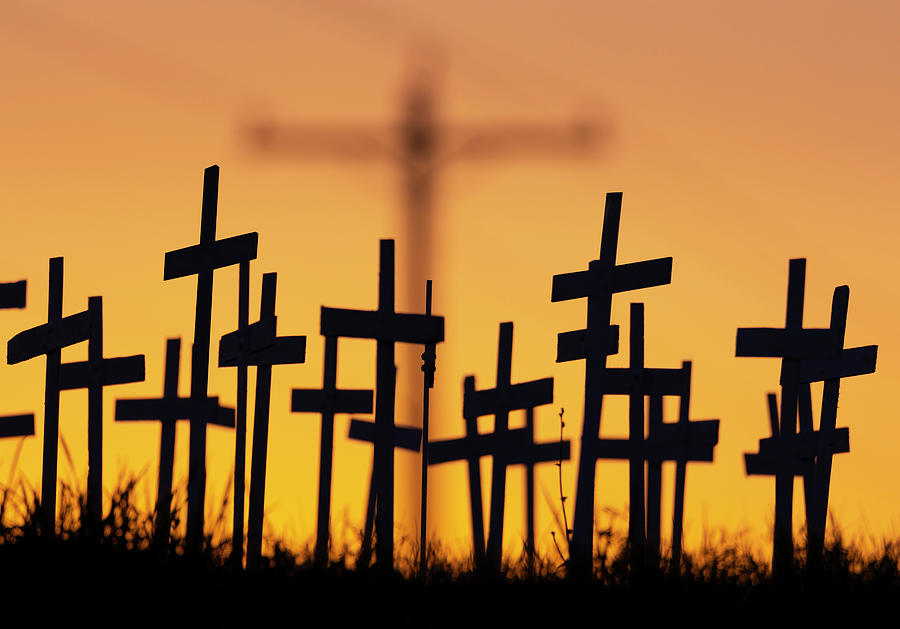Many small crosses silhouetted under one large cross, at sunrise ...
