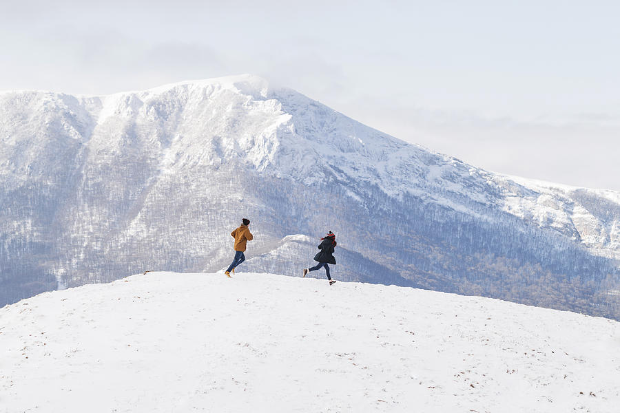 People having fun and running in mountains on the background of high ...